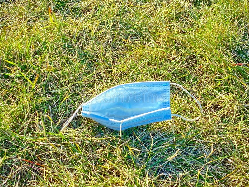 A Face Mask Dumped on a Field. Concept: Waste Garbage during Covid 19 ...