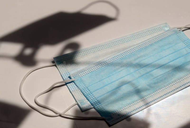 Face Mask on the Table with Shadow Under the Sunlight Stock Photo ...