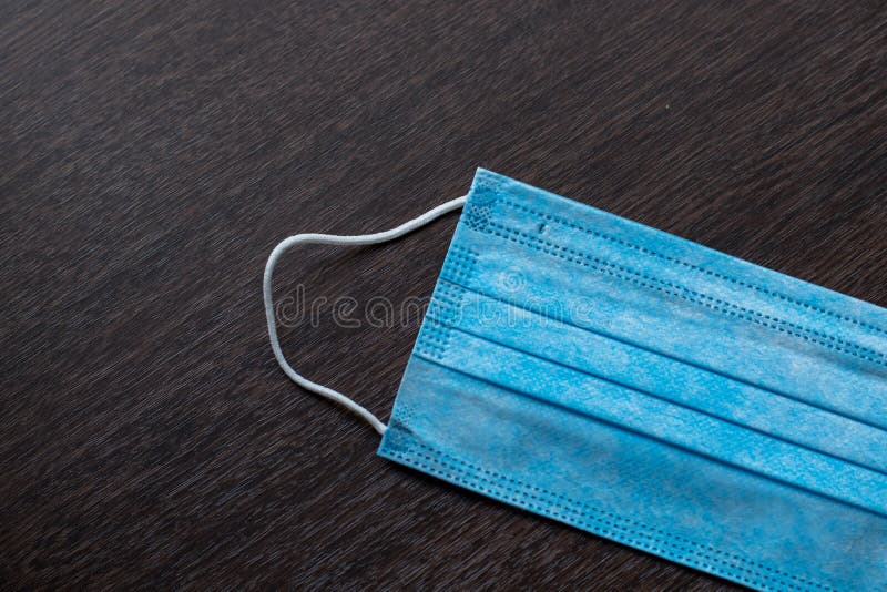 Face Mask on Top of Wooden Desk Stock Image - Image of mask, snack ...