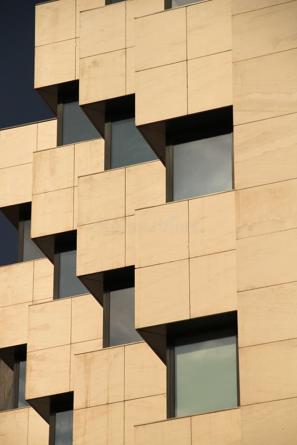 The Face of a Tan Building with Many Windows and a Sky Background Stock ...