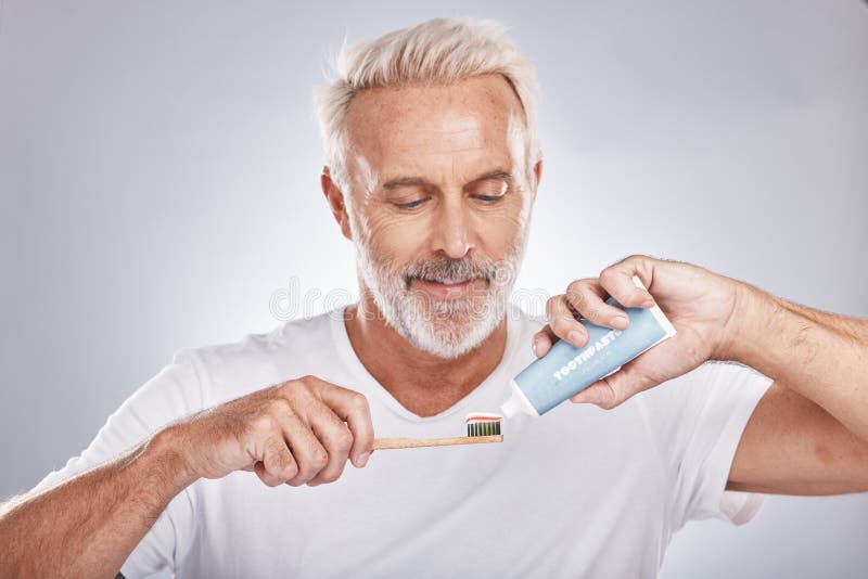Face, Toothpaste and Senior Man with Toothbrush in Studio Isolated on a ...