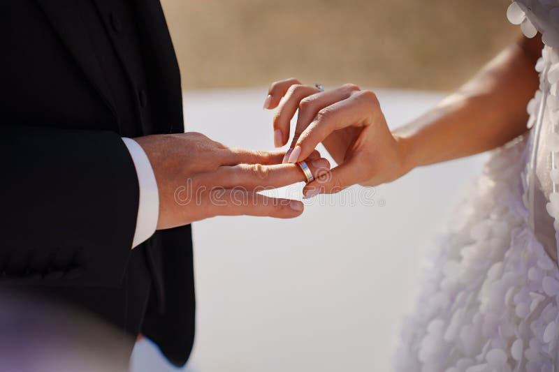 Without Faces. the Bride Puts the Wedding Ring on the Groom S Finger ...