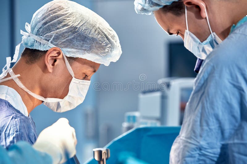 Faces of Surgeons in the Operating Room during the Operation. Modern ...