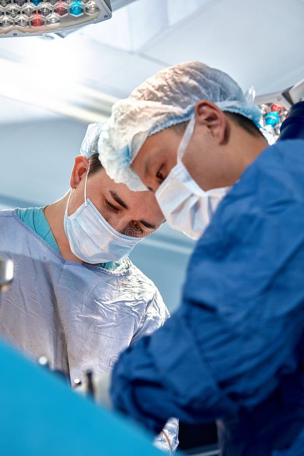 Faces of Surgeons in the Operating Room during the Operation. Modern ...
