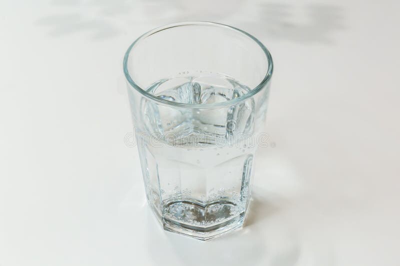 Faceted Glass with Drink Water on a White Table Stock Photo - Image of ...