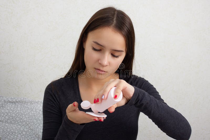 Facial Skin Care A Young Girl Rubs Her Face With A Tonic Nourishing