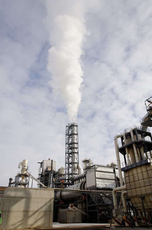 Factory Chimney on Gloomy Blue Sky Background and Green Tree. Stock ...