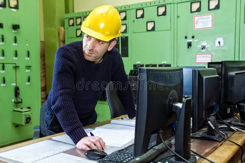 Factory Employee Wearing a Yellow Helmet Working on His Computer Stock ...