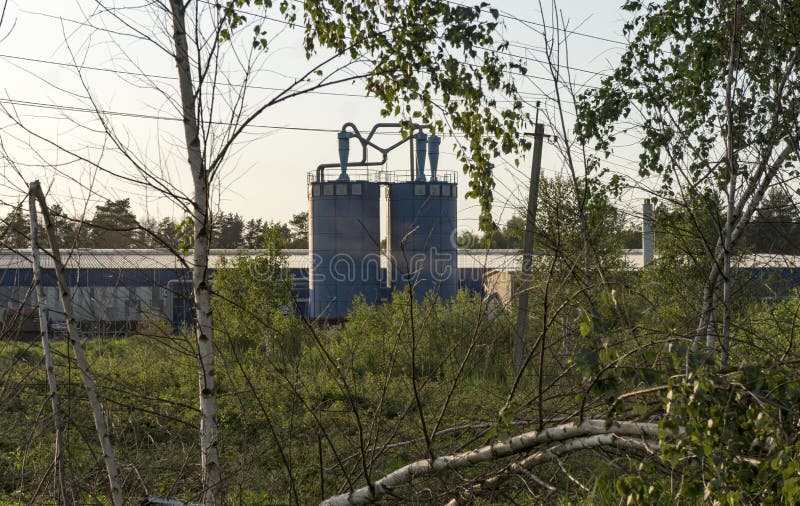 Factory in the Field. Two Large Tanks and a Pipe from Which Smoke Comes ...