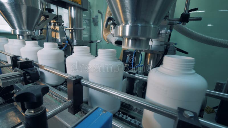 Automatic Process for Inserting Plastic Caps into Bottles. Stock ...