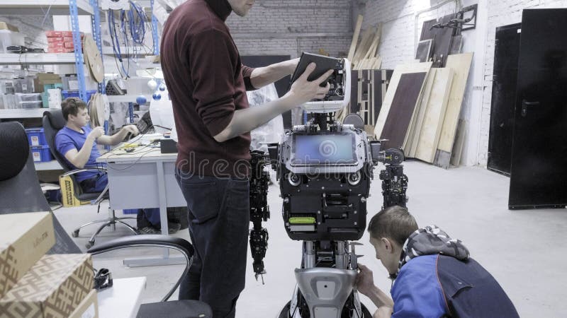 Factory for the Production of Robots. Two Engineers are Examining a ...
