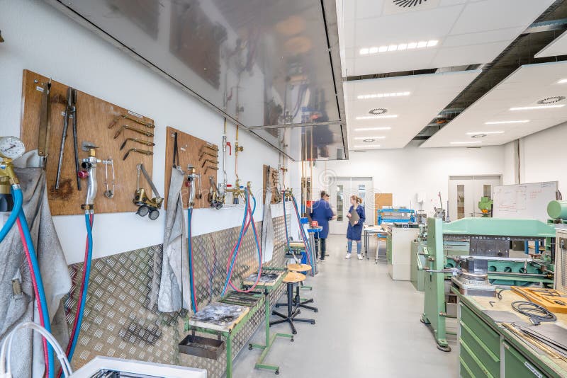 Factory with Tools on the Wall and the Workers in Blue Uniforms Stock ...