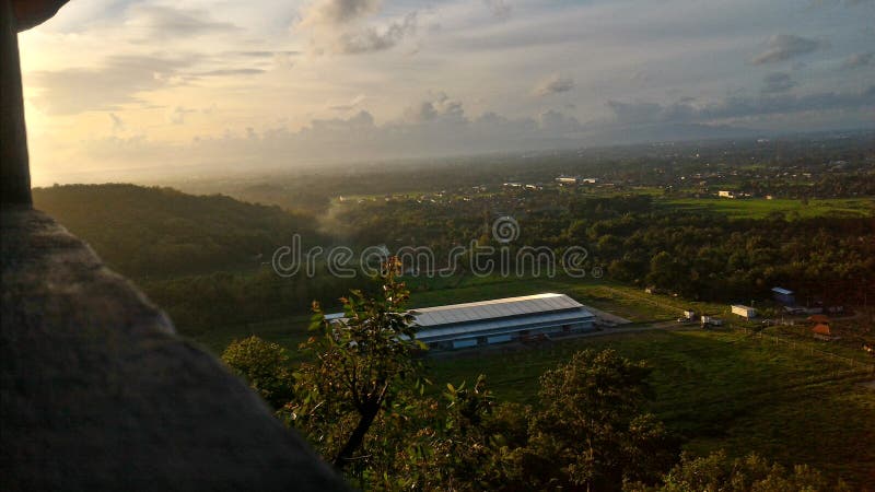 A Factory or Warehouse that is Visible from Afar from the Top of a Hill ...