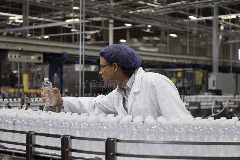 Factory Worker Examining Bottled Water Stock Photo - Image of machinery ...