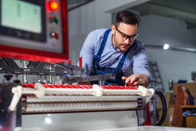 Factory Worker Maintaining Plastic Bag Machine in the Industry. Stock ...