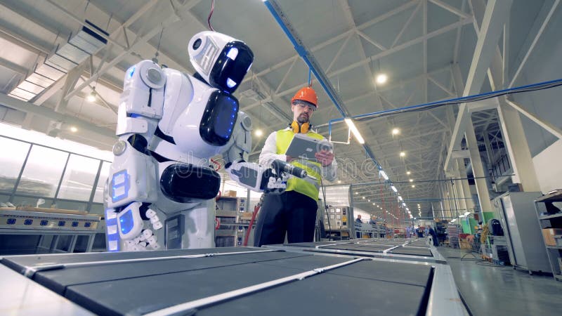 A Factory Worker Switches on a Droid, Controlling it. Stock Video ...