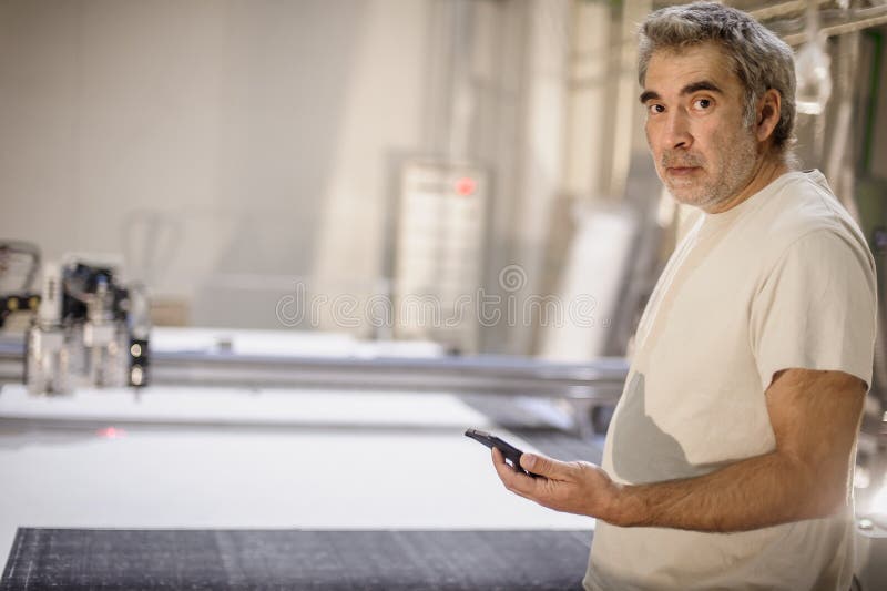 Factory Worker Resting and Using Mobile Phone in Workshop Stock Photo ...