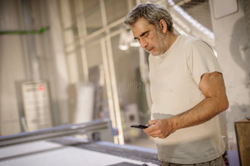 Factory Worker Resting and Using Mobile Phone in Workshop Stock Image ...