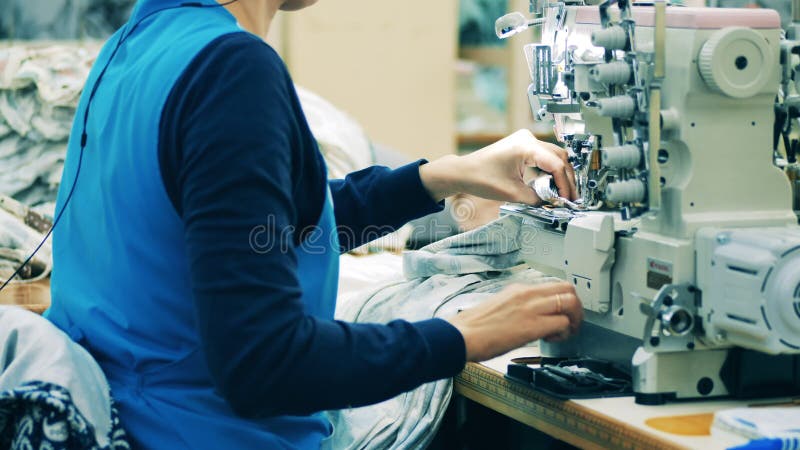 Factory Worker is Sewing Fabric with a Machine and Checking it Stock ...