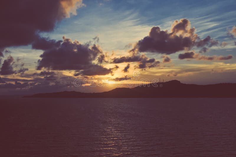 Faded Sunset Over Ocean With Land Stock Photo - Image of ocean, sunset ...