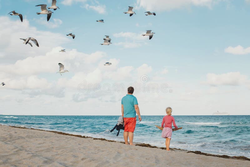 Fader Och Dotter Står På Havets Strand Och Tittar På Seaguller I Himlen
