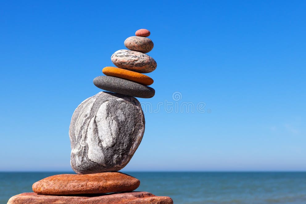 The Fall of the Pyramid of Balanced Stones on Blue Sky Background Stock ...