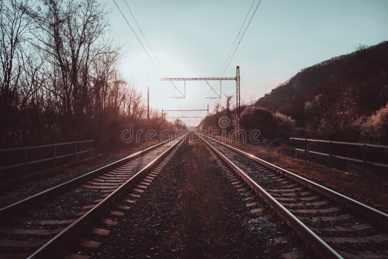 Fall Scene with Railway Tracks Surrounded by Bare Trees and Hills ...