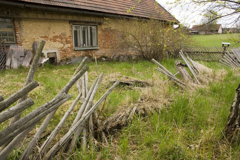 An Old, Crumbling Rural House with a Broken Wooden Fence. Stock Image ...