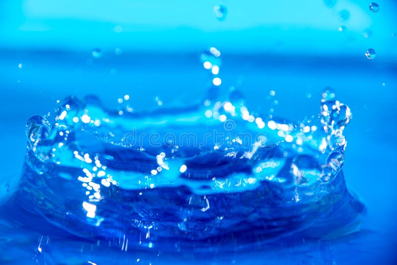 A Falling Drop in the Blue Water. the Waves Diverge from the Drop Stock ...