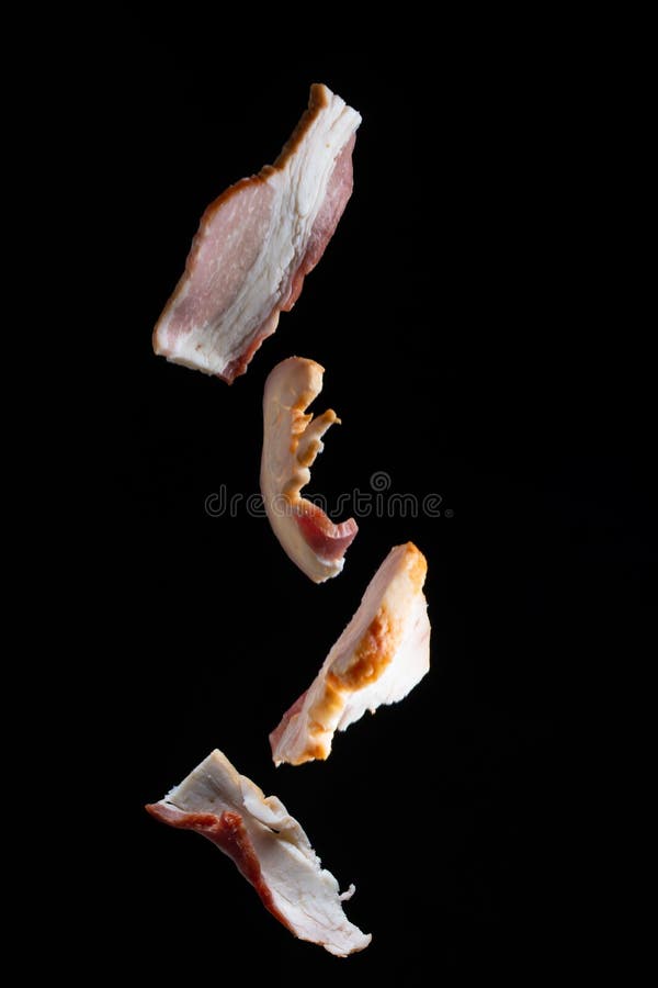 Falling Pieces of Bacon on a Black Background, Freeze in Motion, for ...