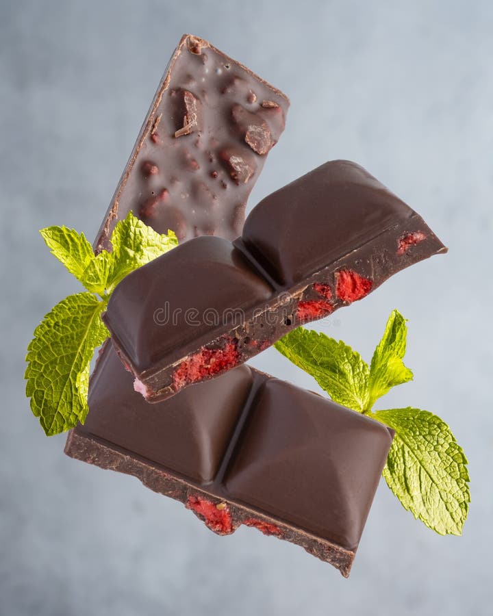 Falling Pieces of Chocolate and Mint Leaves on a Light Background ...