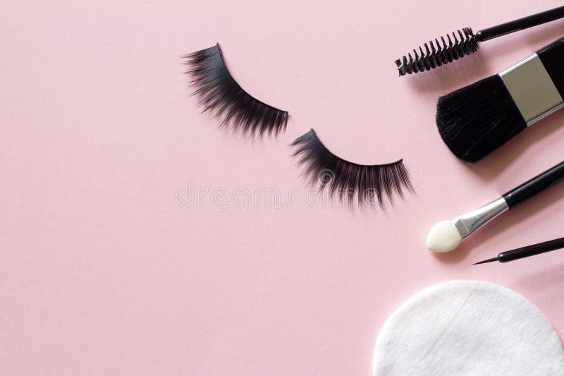 False Eyelashes and Cosmetic Tools for Eye Makeup on Pink Background ...