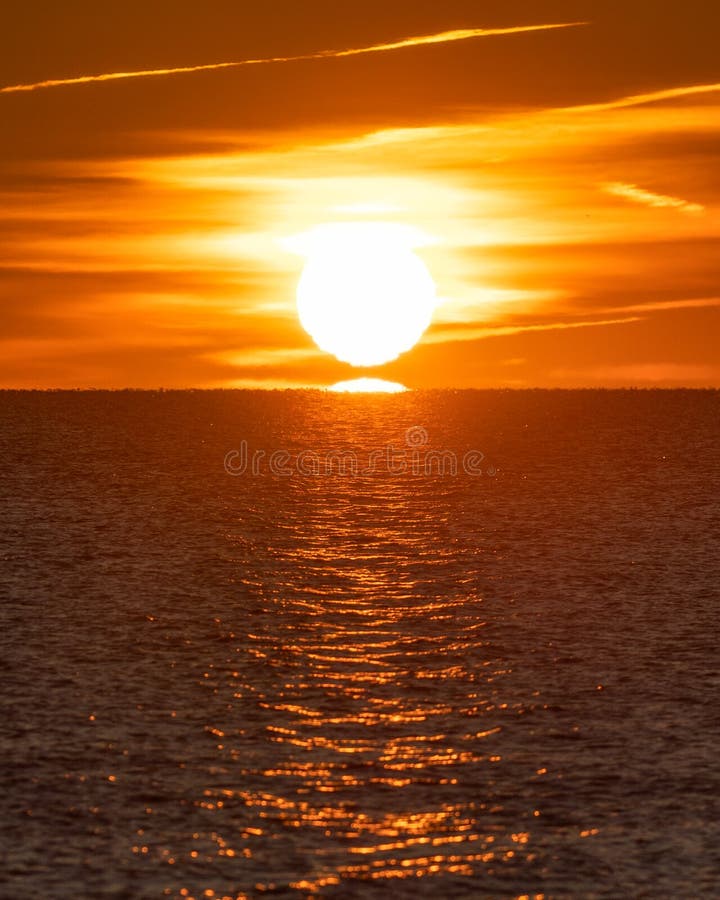 False Sunset Reflected in Water As the Sun Approaches the Horizon, and ...