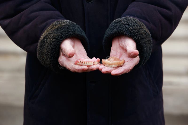 False teeth in old hands stock photo. Image of senior - 173469948