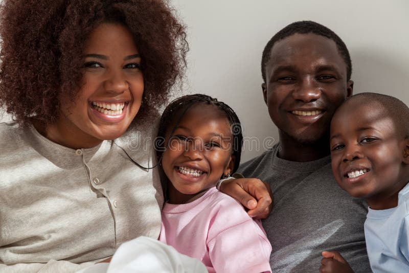 Familia negra en la cama imagen de archivo. Imagen de familia - 62746593