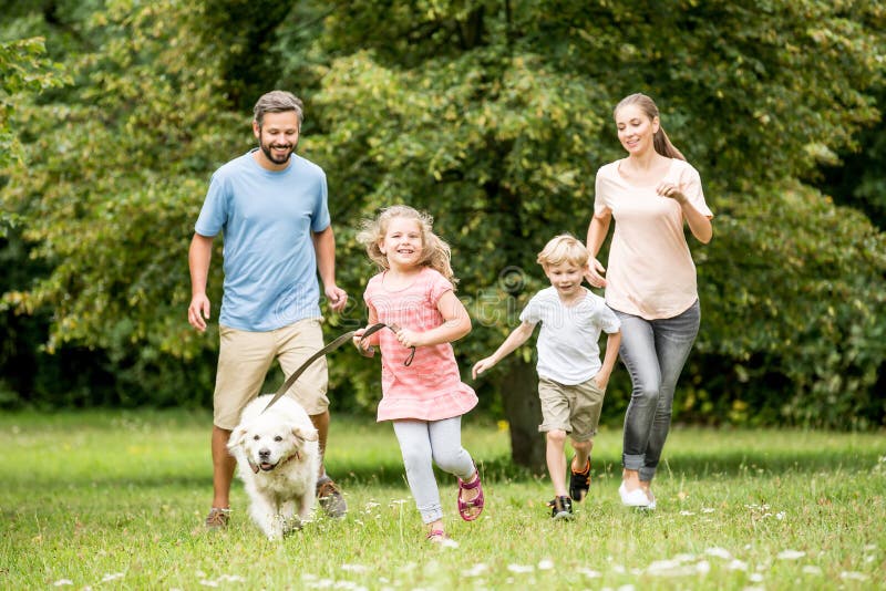 Familie die met hond lopen stock foto. Image of geluk - 100529514