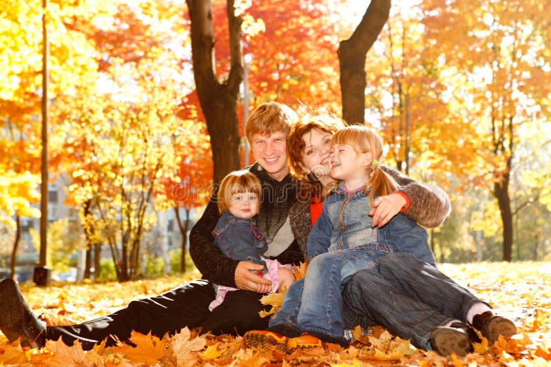 Family on autumn leaves stock image. Image of park, autumnal - 11280797