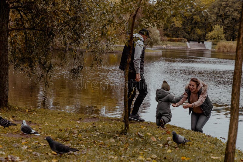 Family in an Autumn Park Chasing Pigeons and Ducks Stock Image - Image ...