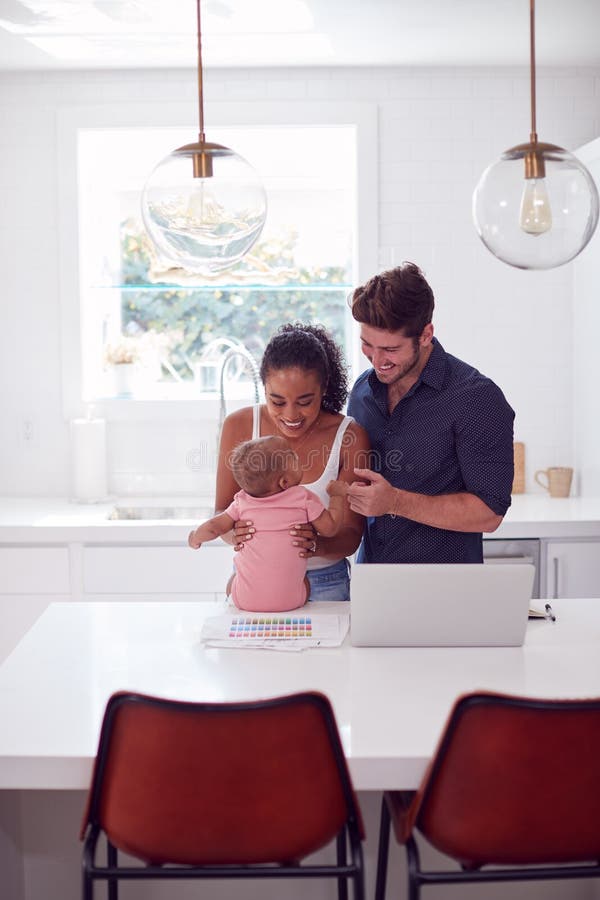 Family with Baby Daughter in Kitchen Using Laptop on Counter Stock ...