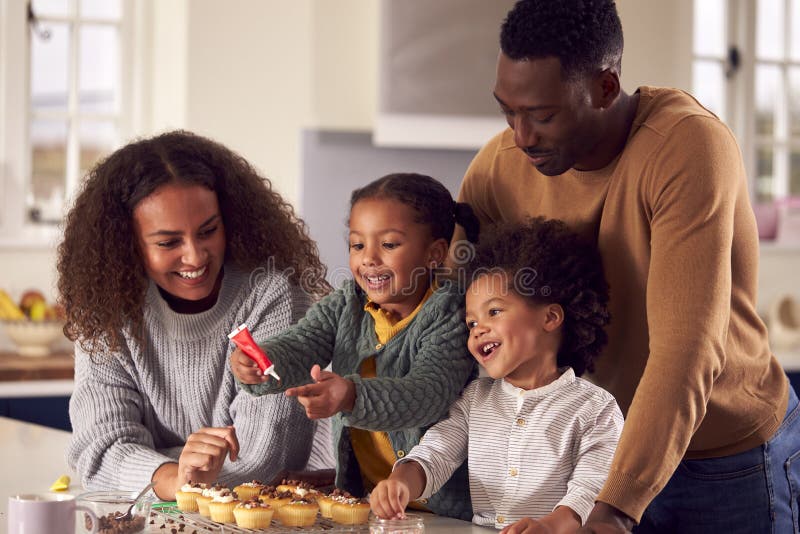 Family Baking Cupcakes Sitting Around Kitchen Counter at Home Stock ...