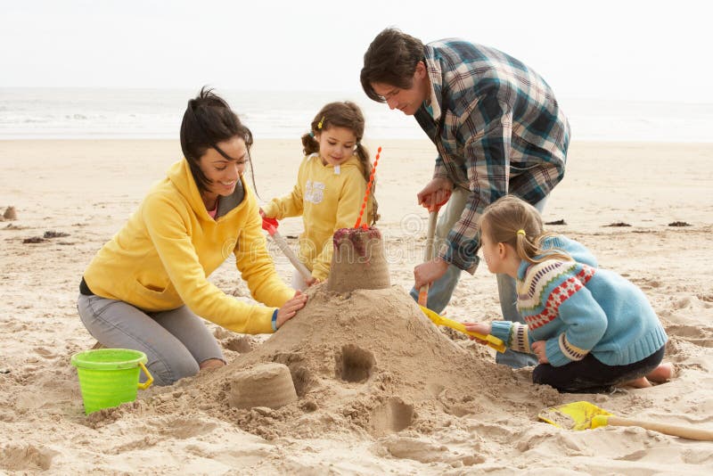 Family Building Sandcastle on Winter Beach Stock Photo - Image of ...