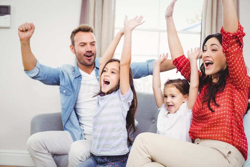 Family Cheering while Watching TV at Home Stock Image - Image of family ...