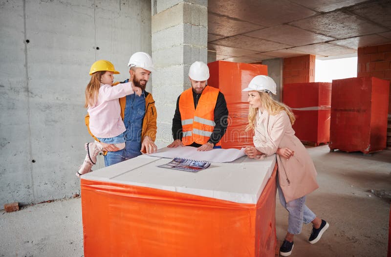 Family Discussing Building Plan with Builder at Construction Site ...