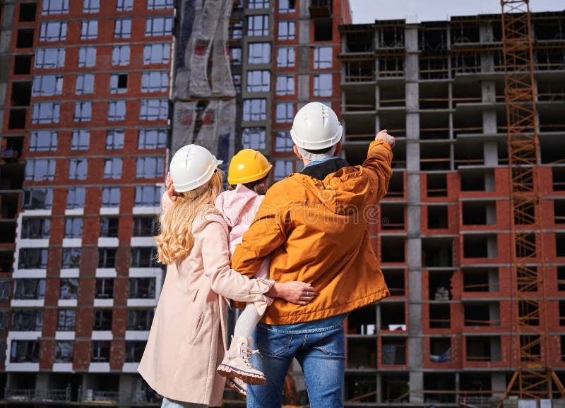 Family with Child Looking at Apartment Building Under Construction ...