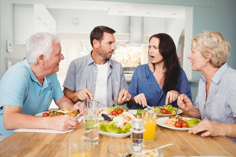 Family Discussing while Sitting at Dining Table Stock Image - Image of ...