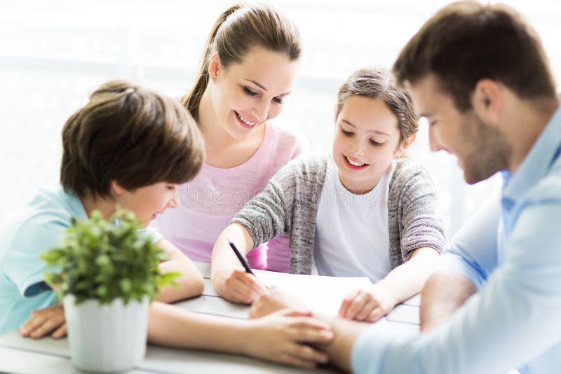 Family Doing Homework Together at Table Stock Photo - Image of daughter ...