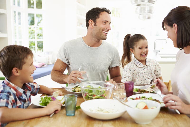 Family Eating Meal Around Kitchen Table Together Stock Photo - Image of ...