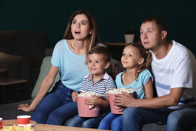 Family Eating Popcorn while Watching TV in Evening Stock Photo - Image ...