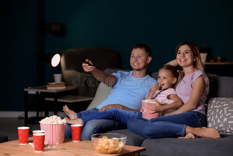 Family Eating Popcorn while Watching TV in Evening Stock Photo - Image ...