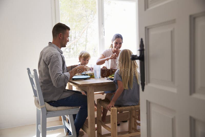 Family Sitting Down To Eat Lunch at Kitchen Table Stock Photo - Image ...